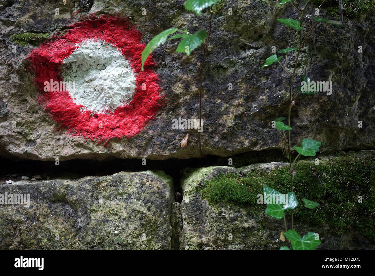 Red sign of hiking trail on the stone wall Stock Photo - Alamy