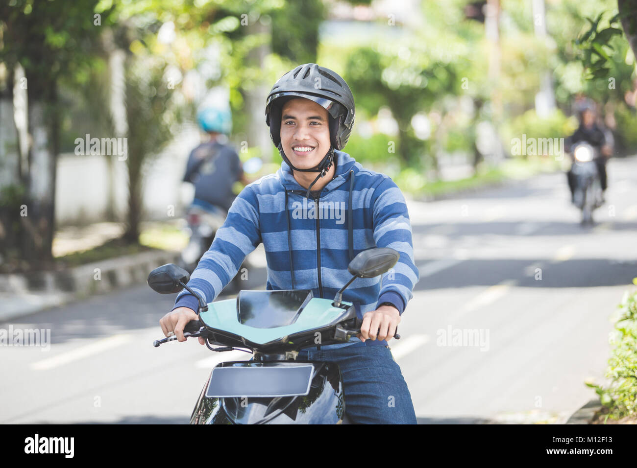 portrait of happy asian man riding on motorbike in city street Stock ...