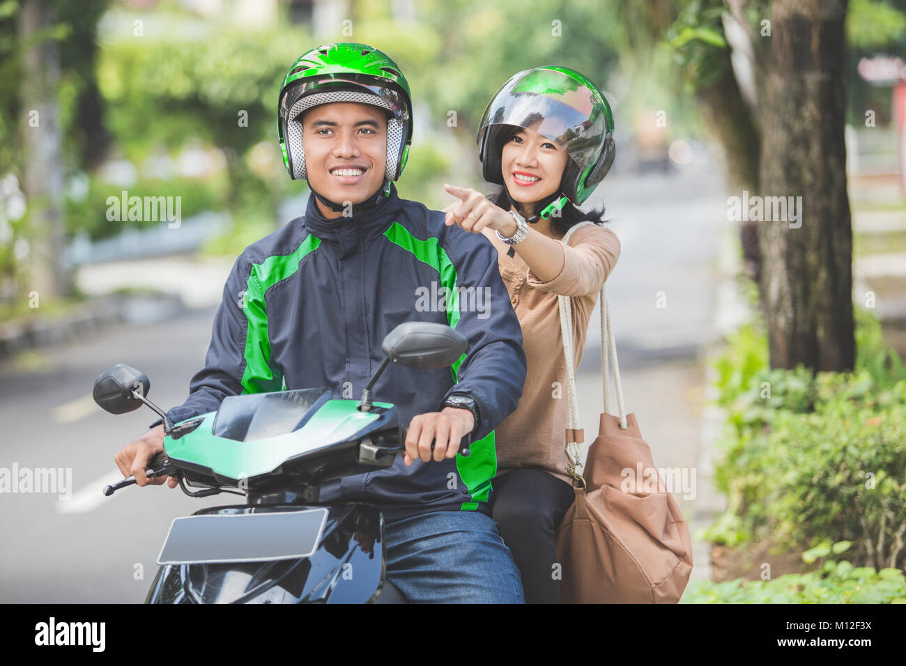 happy passenger directing commercial motorcycle taxi driver to go to ...