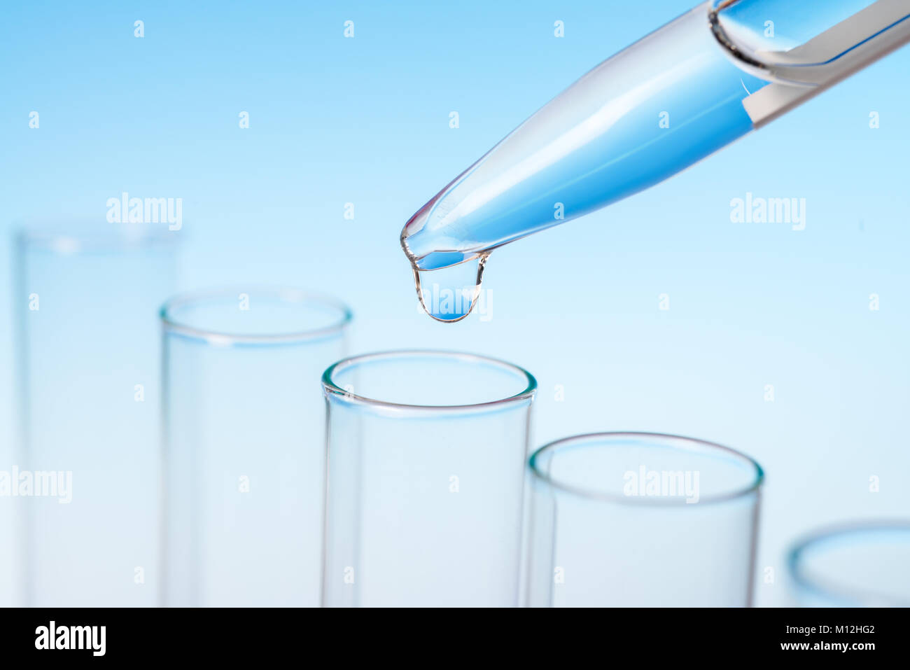 Scientific background: drop from pipette falling in a tube, text space ...
