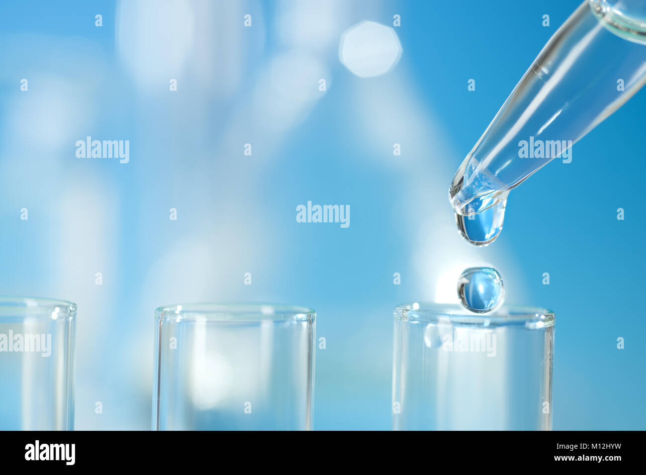Scientific background: drop from pipette falling in a tube, text space ...