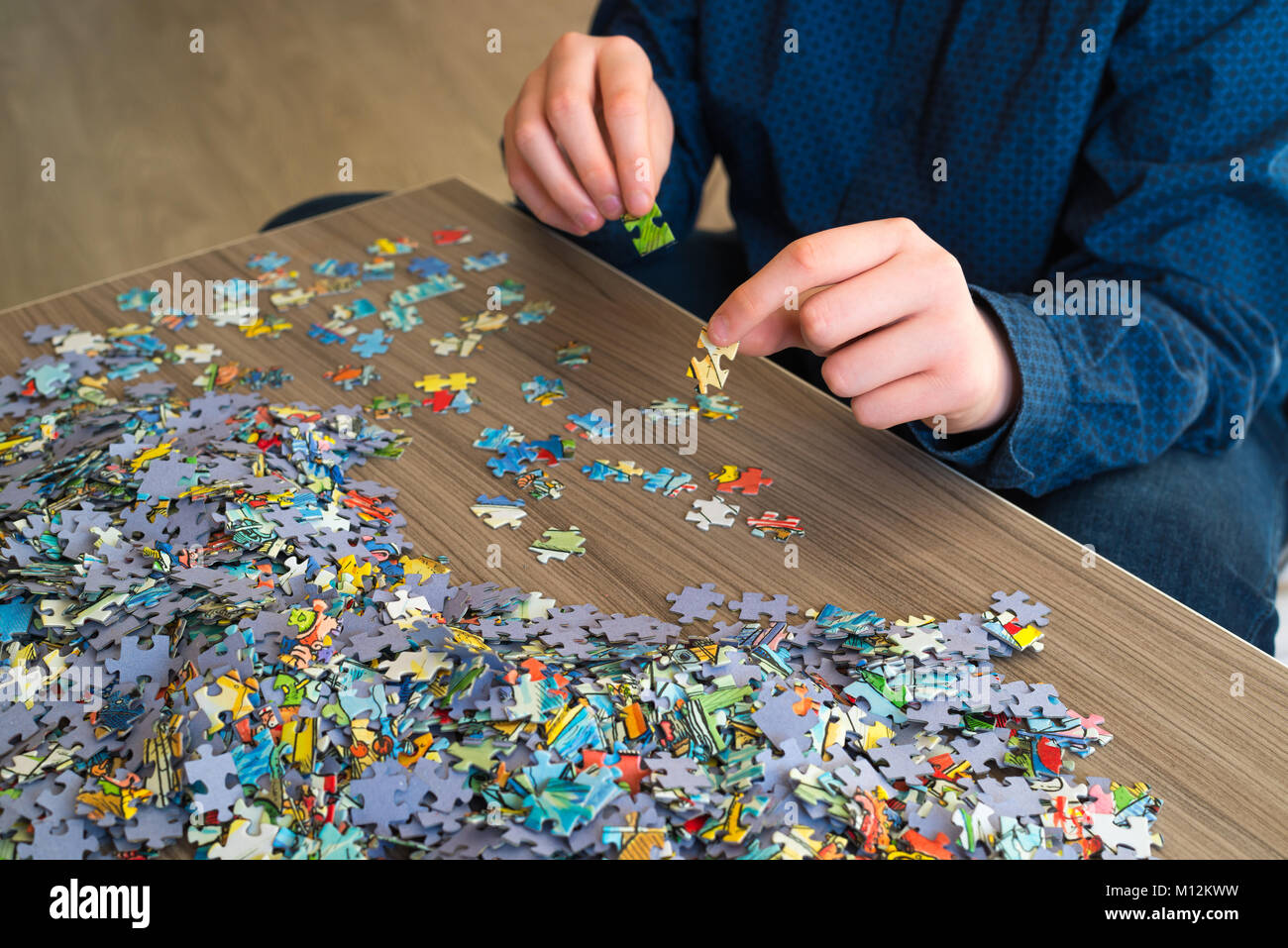 A teenager collects puzzles on a coffee table Stock Photo - Alamy