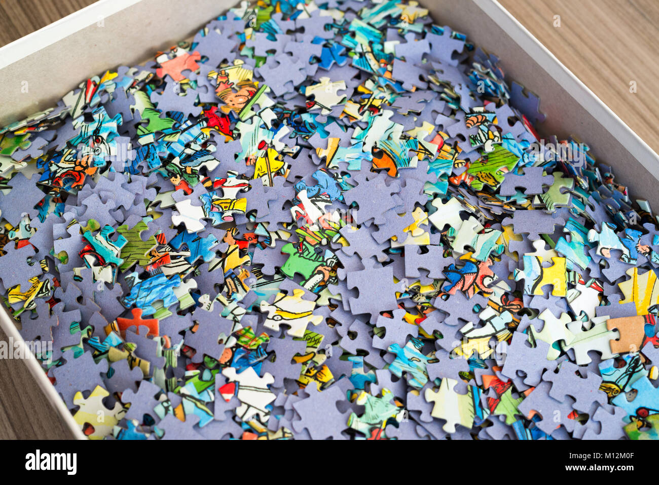 A pile of puzzles in box lies on the table Stock Photo - Alamy