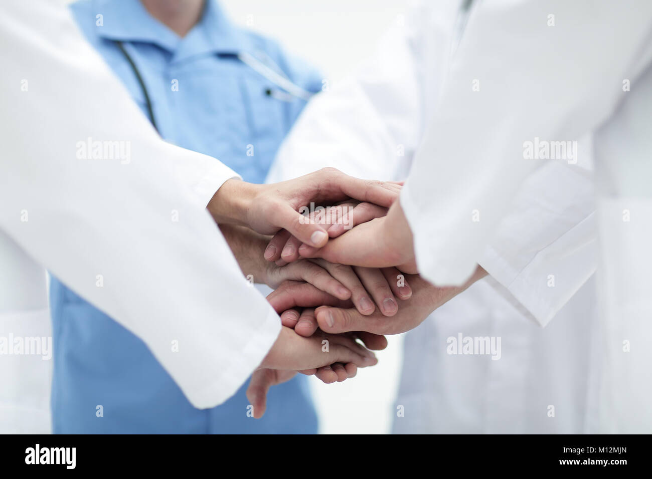 Group doctors joining hands hi-res stock photography and images - Alamy