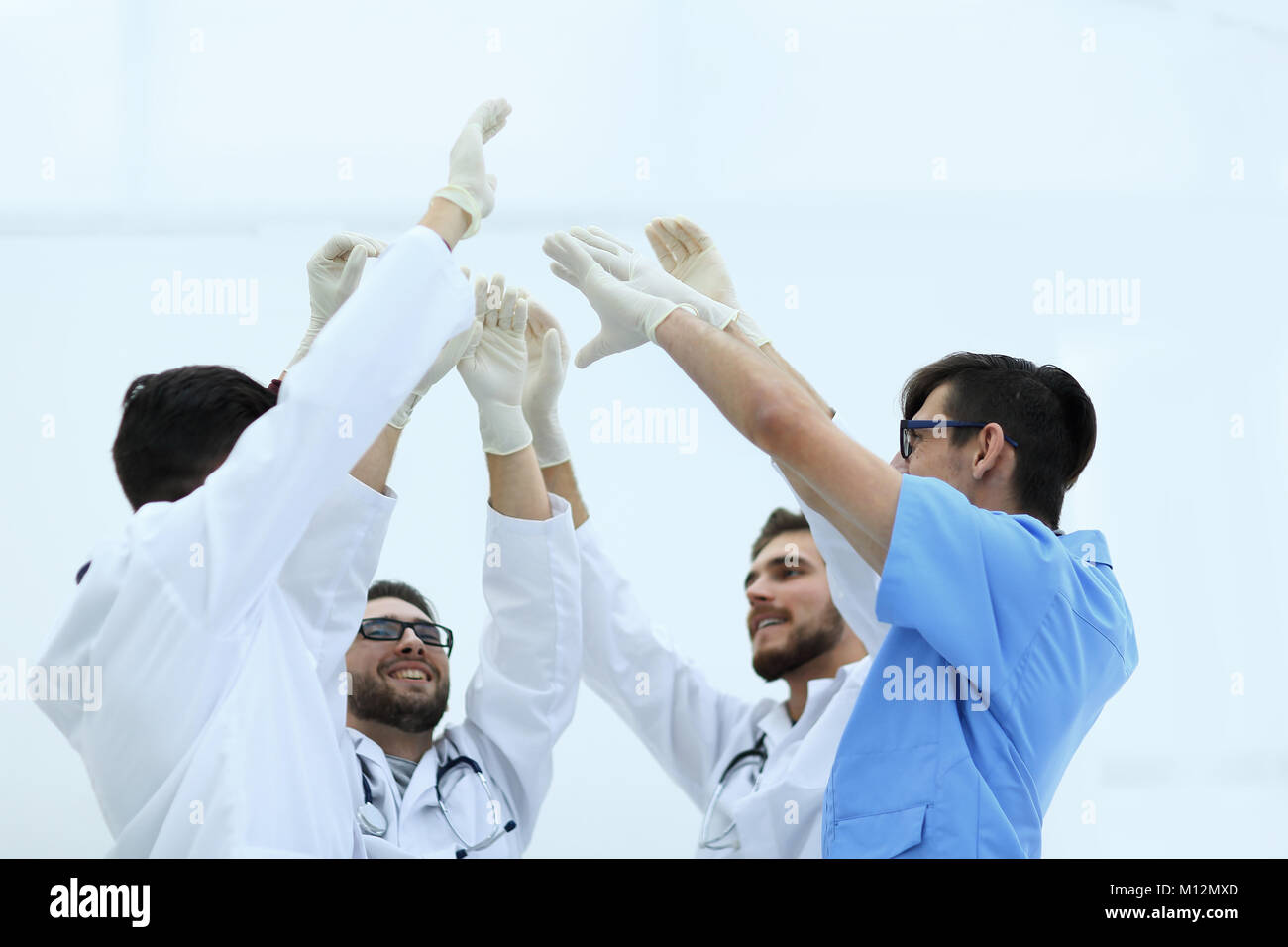 surgical team raising their hand Stock Photo - Alamy