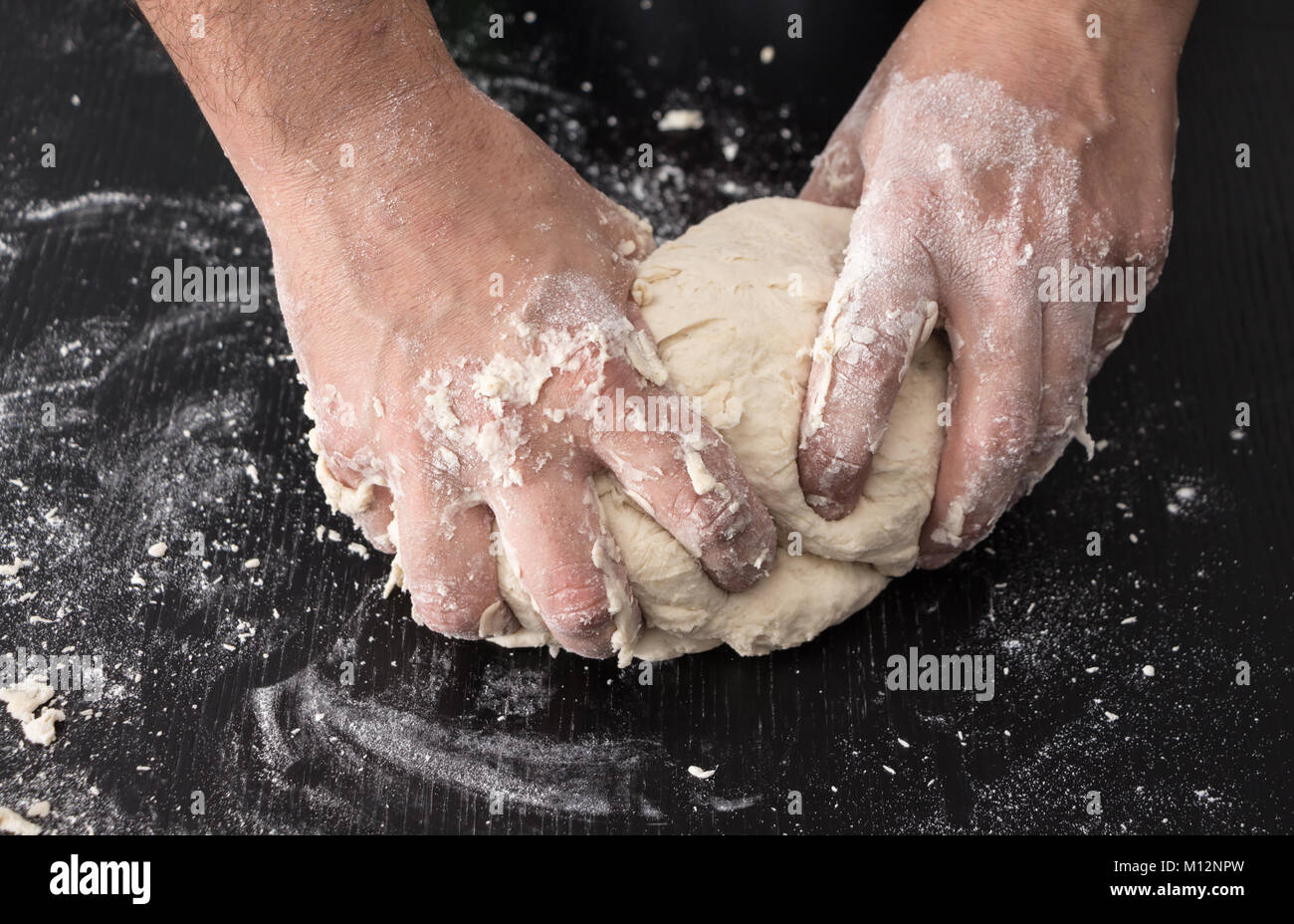 Male hands kneading dough, baking preparation closeup Stock Photo - Alamy