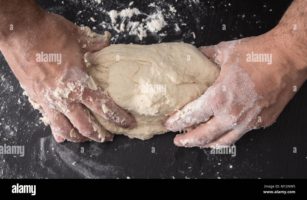 Male hands kneading dough, baking preparation closeup Stock Photo - Alamy