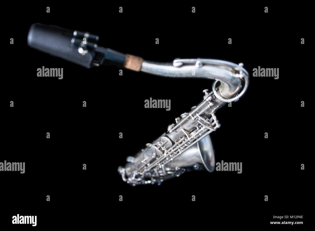 Full view of a silver saxophone standing isolated in black Stock Photo ...