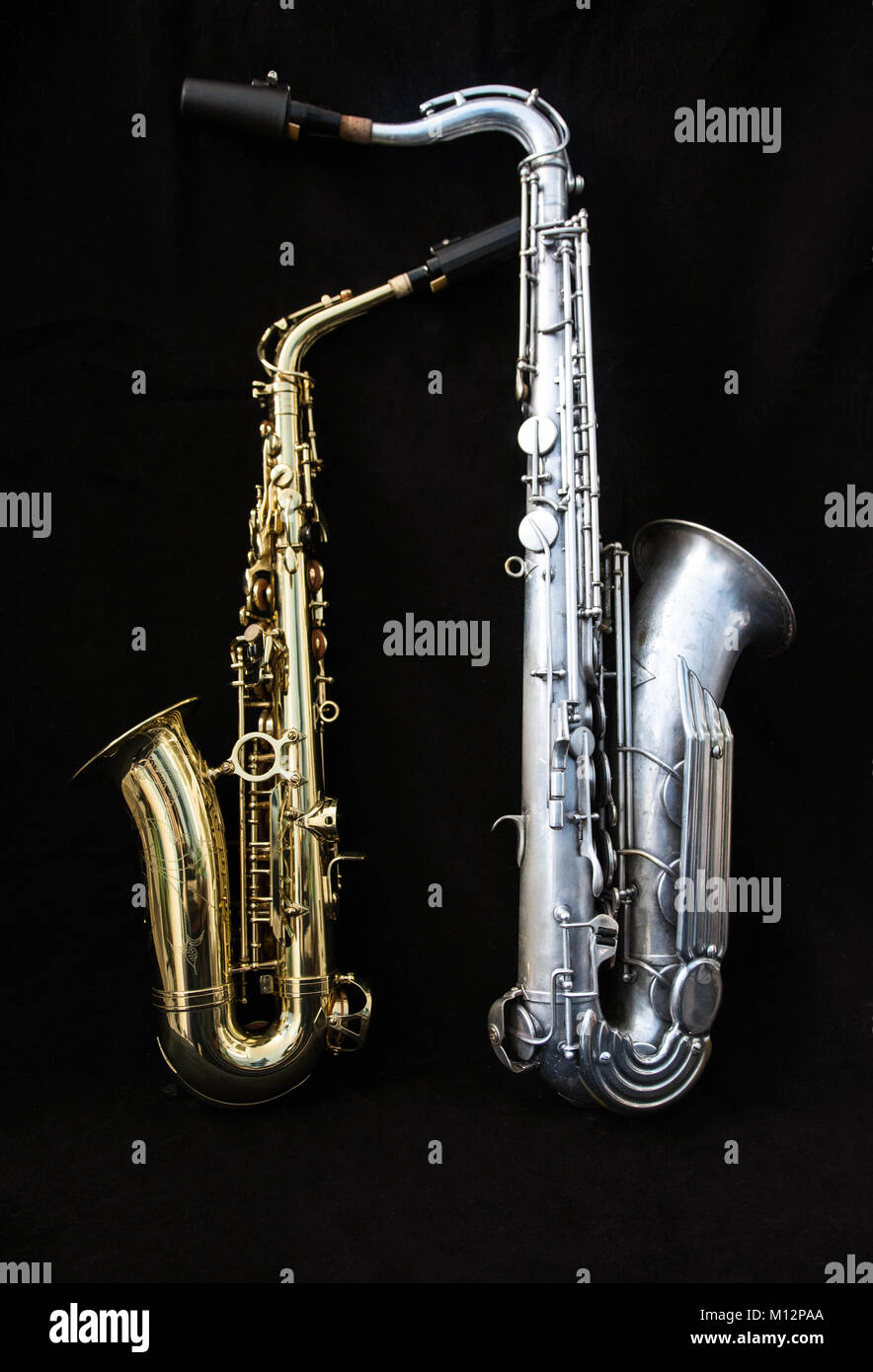 Full view of two saxophones standing isolated in black Stock Photo - Alamy