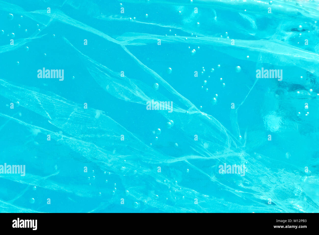 background, texture - blue translucent surface of ice with bubbles and ...
