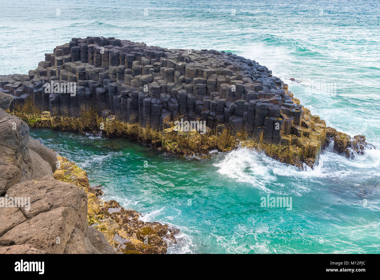 Crescent shaped hexagonal rock formations at Fingal Head, Australia ...