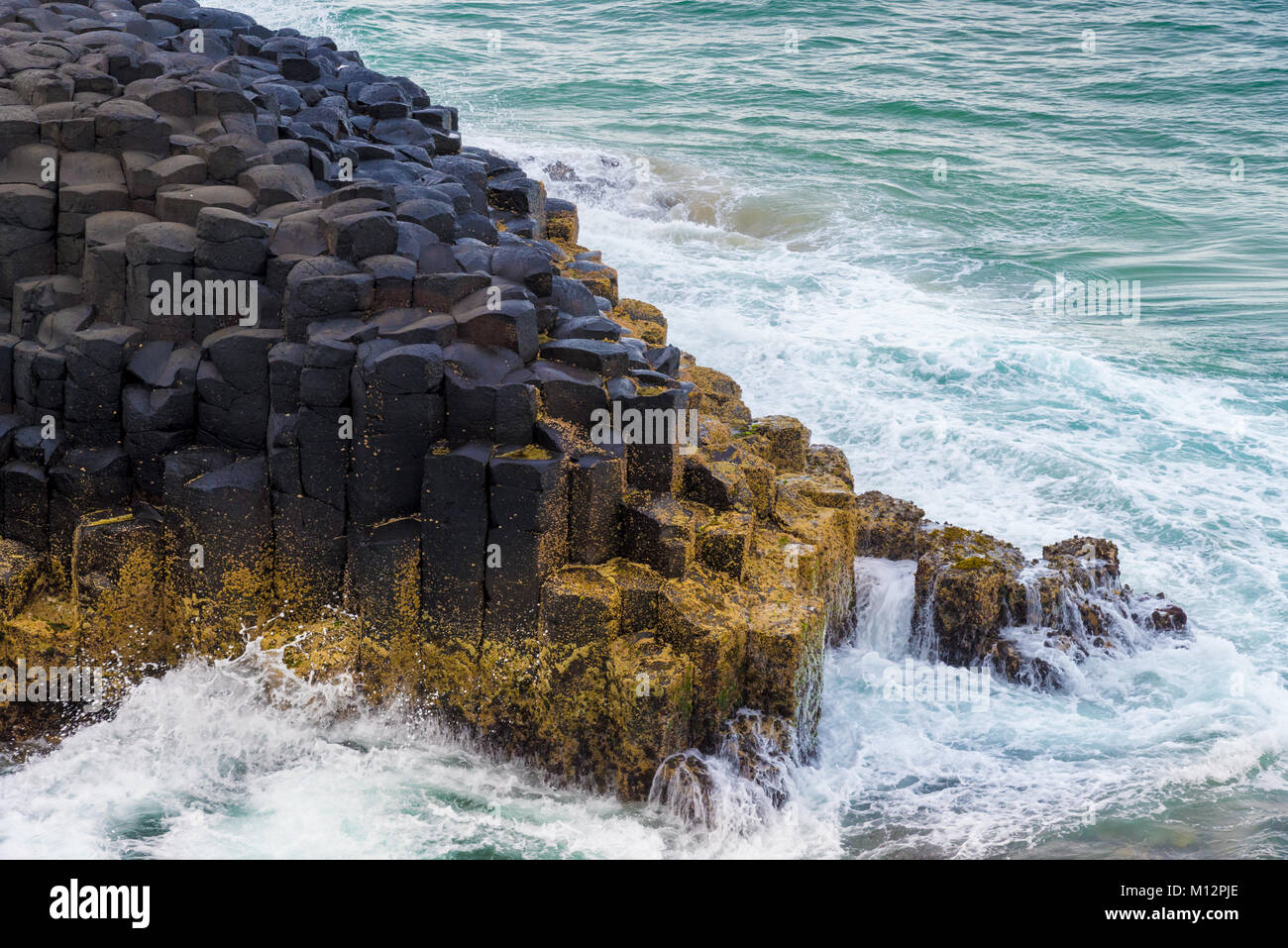 Crescent shaped hexagonal rock formations at Fingal Head, Australia ...