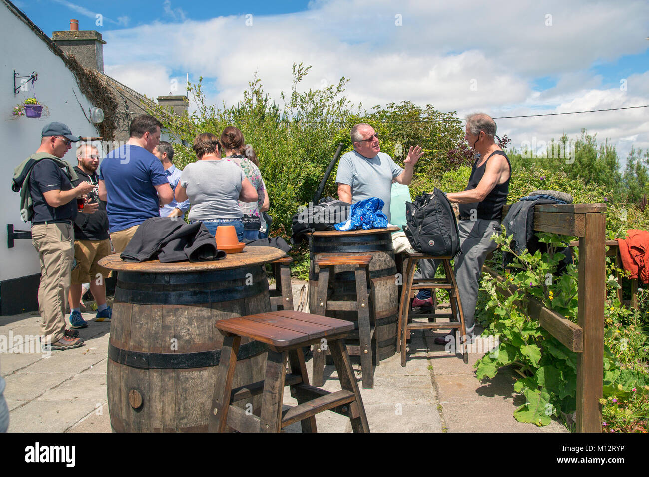 Drinking in the sun outside the Jolly Roger Stock Photo - Alamy