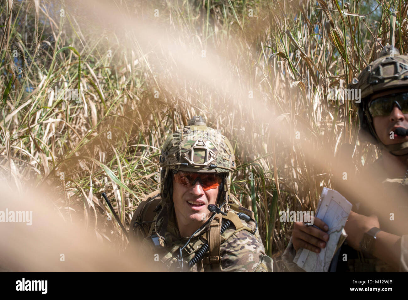 Staff Sgt. David R. Cunningham utilizes the vegetation for cover ...