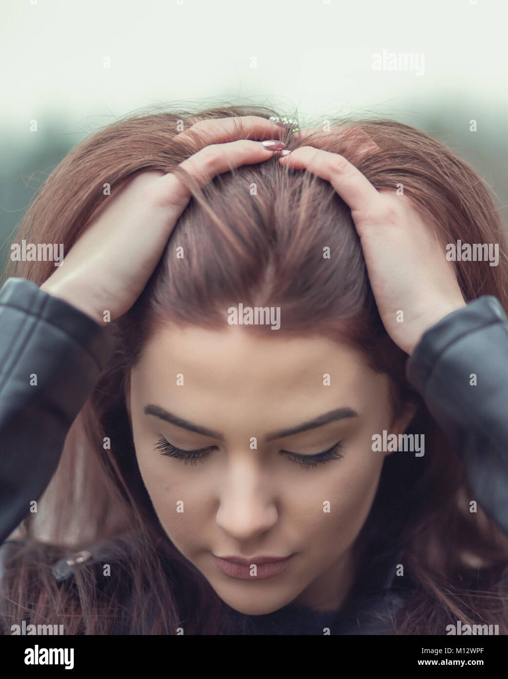 Stressed Attractive Young Woman Running Her Hands Through Her Long Brown Hair As She Takes A