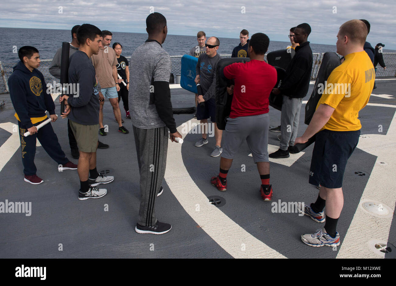 OCEAN (Jan. 22, 2018) Gunner's Mate 1st Class Gregory Bissett, center ...