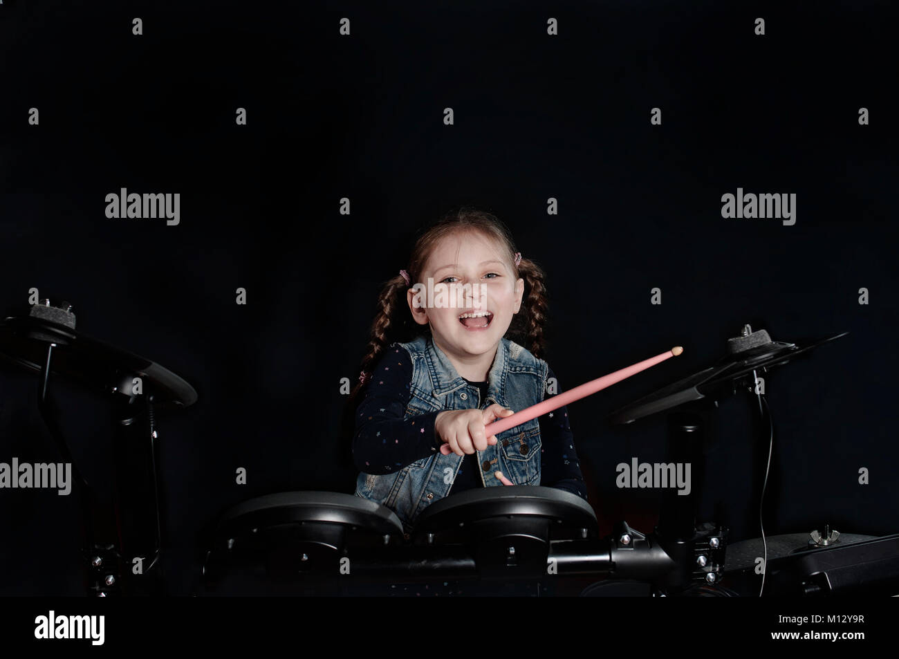 Little caucasian girl drummer laughting Stock Photo - Alamy