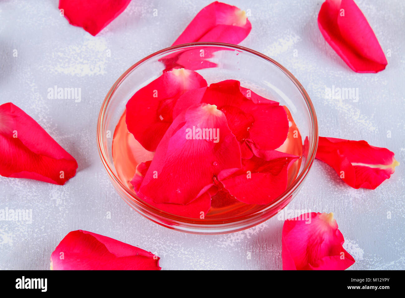 Pink water from rose petals on a gray table. Spa Stock Photo - Alamy