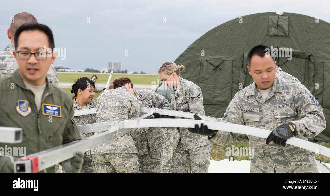 Members of the 18th Medical Group assemble a tent near the flightline ...