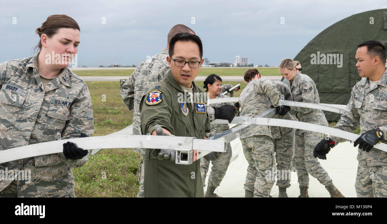 Members of the 18th Medical Group assemble a tent near the flightline ...