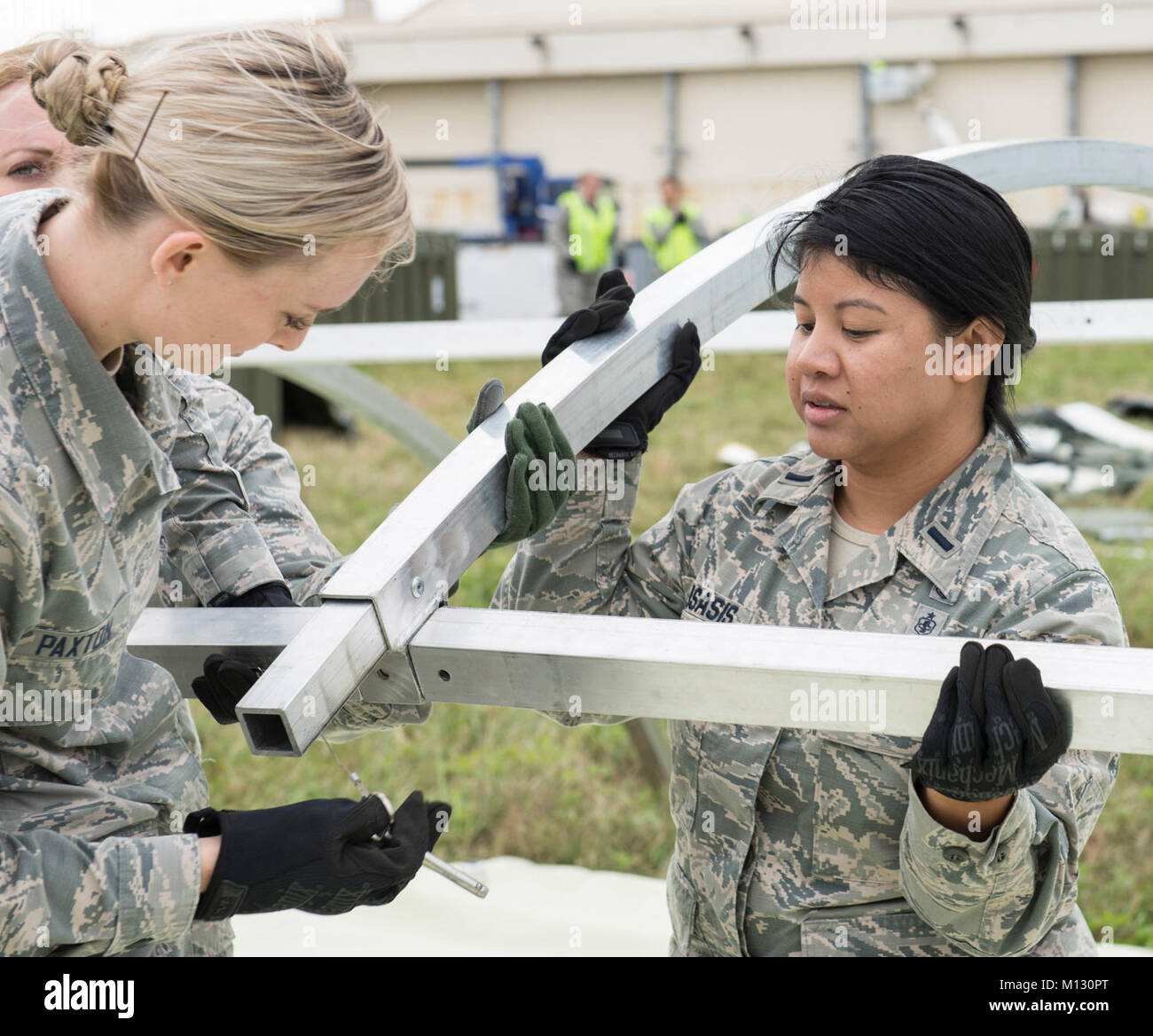 Members of the 18th Medical Group assemble a tent near the flightline ...