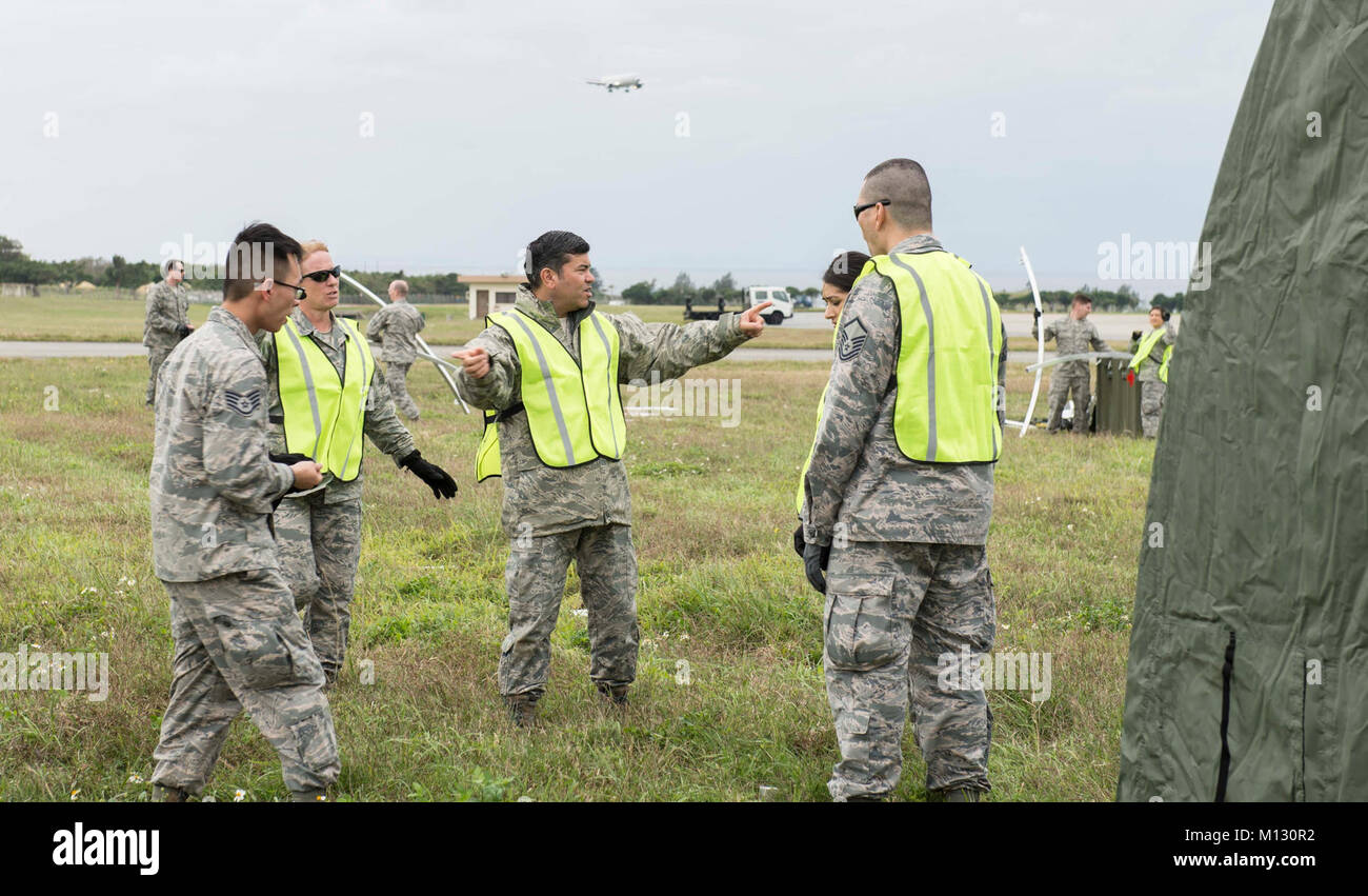 Members of the 18th Medical Group discuss assembling a tent near the ...