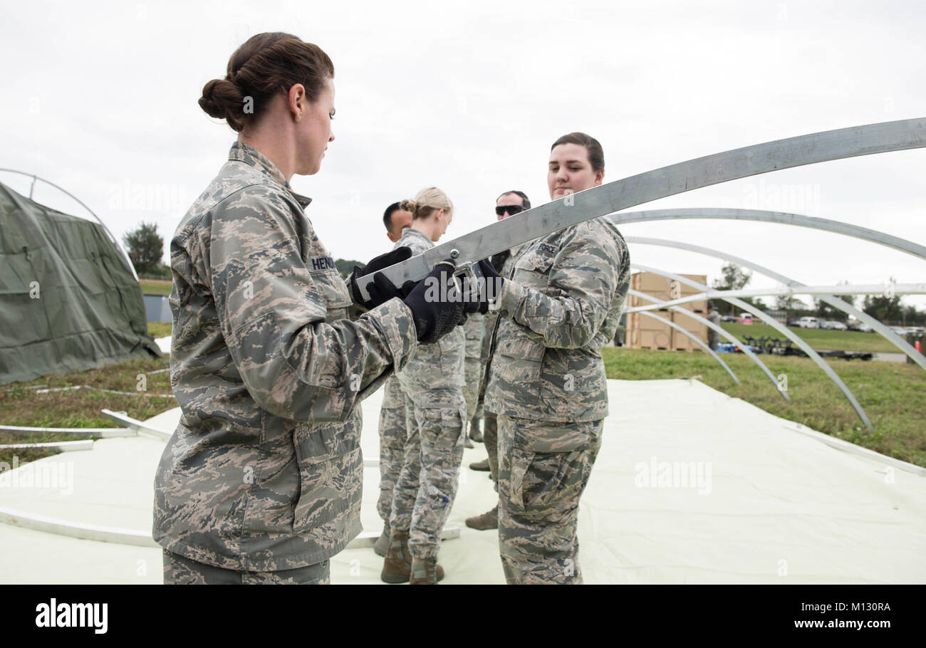 Members of the 18th Medical Group assemble a tent near the flightline ...