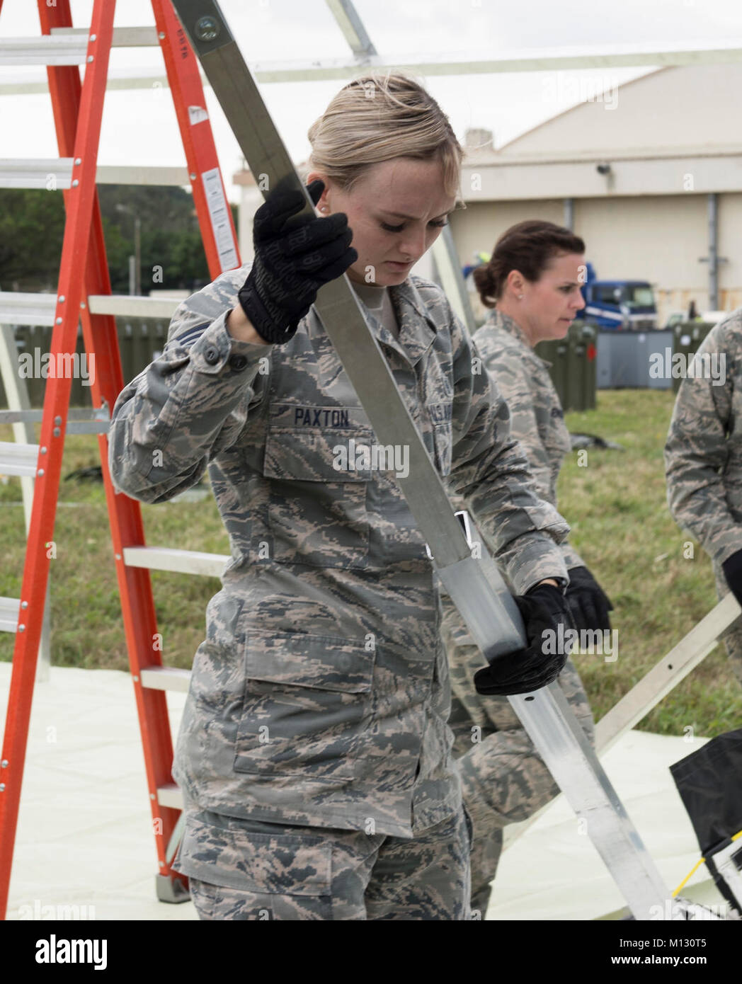 A member of the 18th Medical Group assemble a tent near the flightline ...