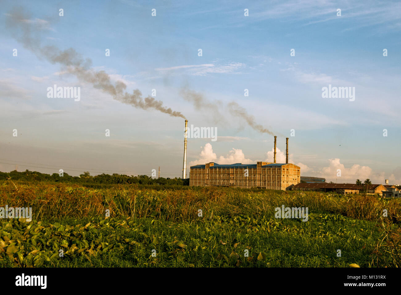 A smoking factory emitting black smoke into air Stock Photo - Alamy