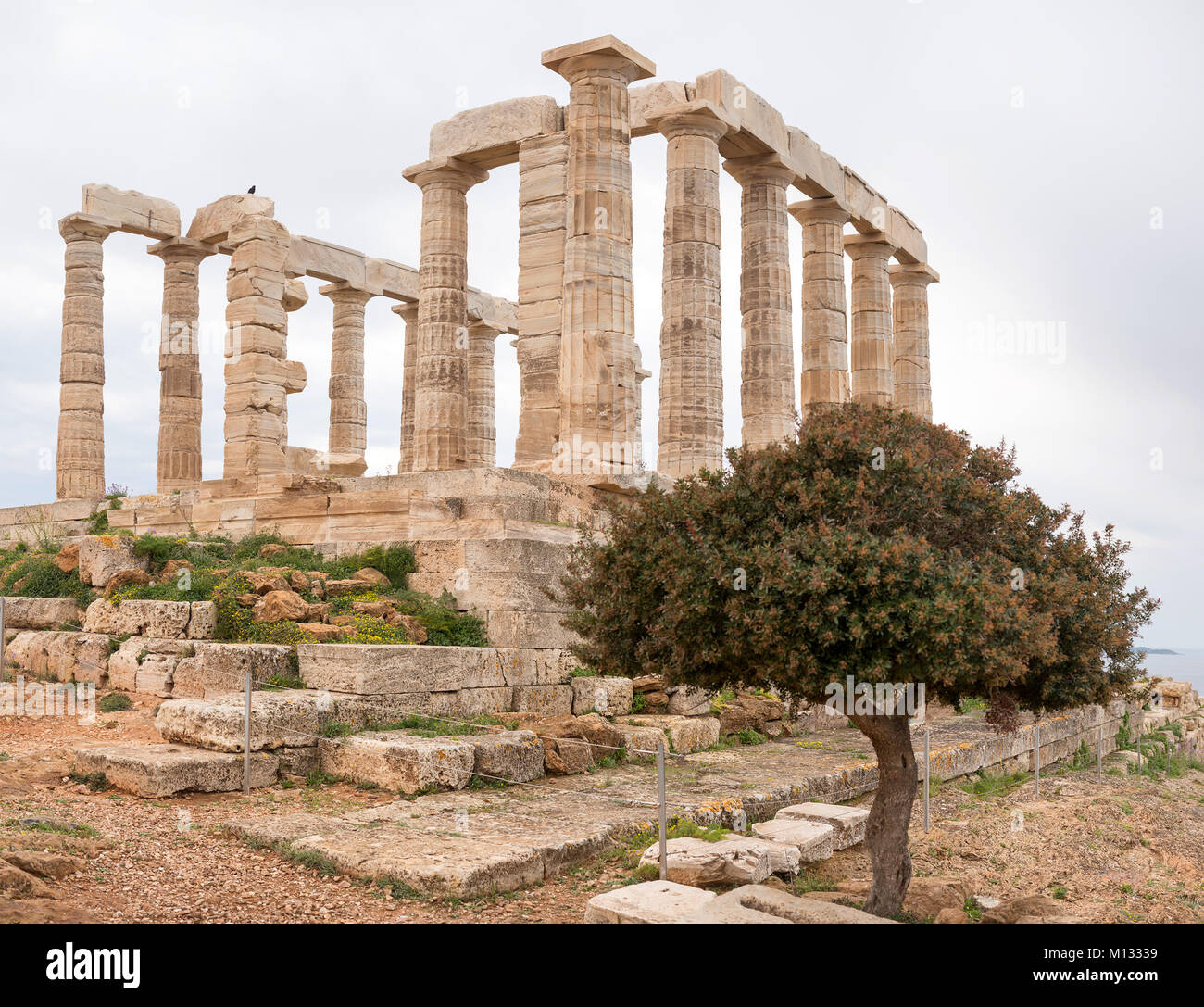 Ruins of an ancient Greek temple of Poseidon under dramatic cloudy sky ...