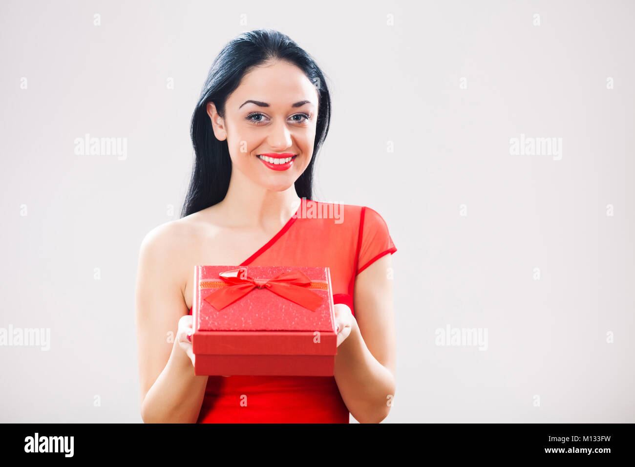 Happy girl holding gift box Stock Photo - Alamy