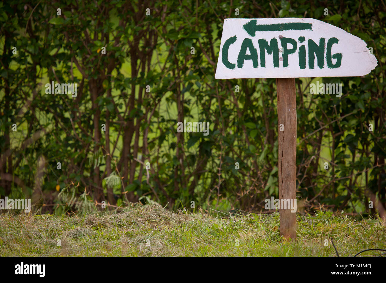 A wooden camping hand painted sign with the arrow pointing to the left ...