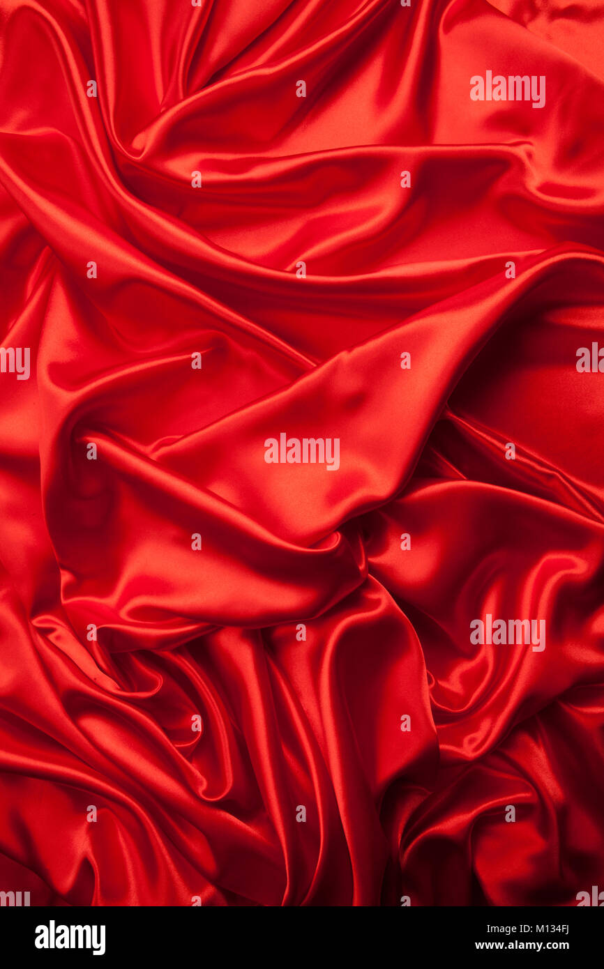 close-up view of a red piece of satin fabric. Minimal color still life ...