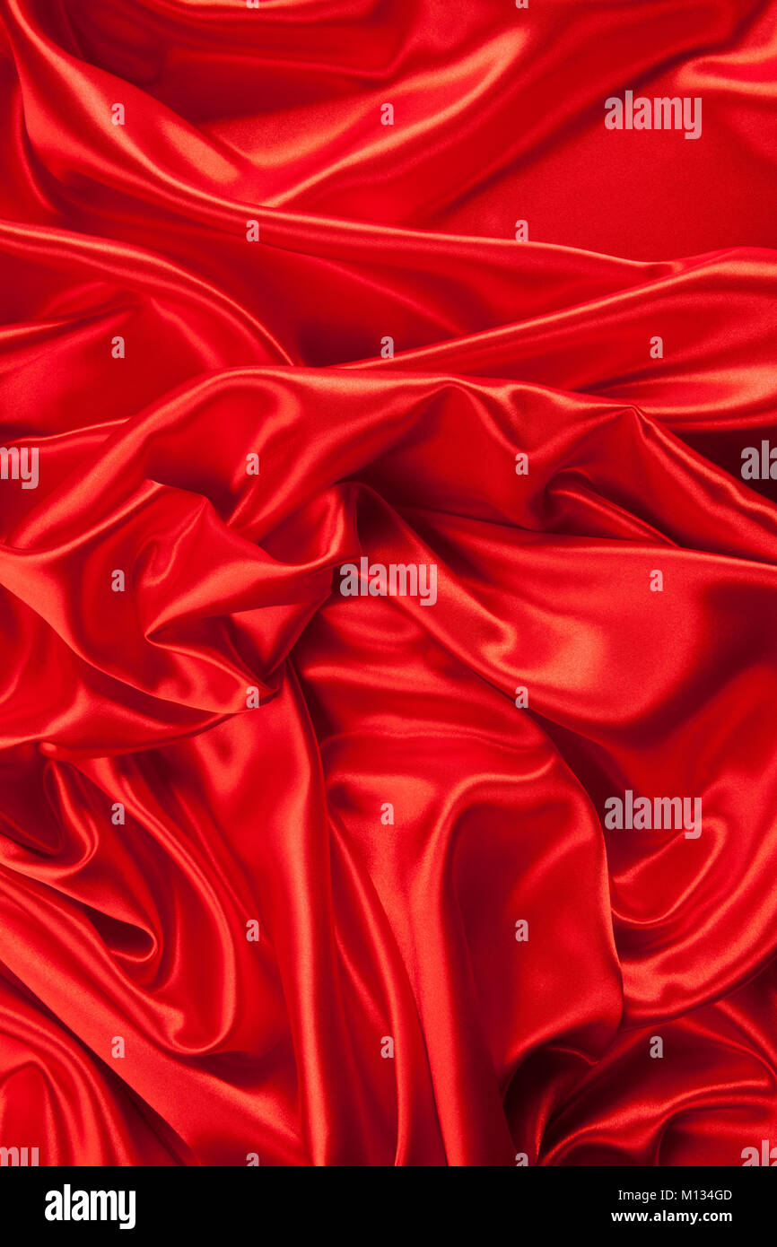 close-up view of a red piece of satin fabric. Minimal color still life ...