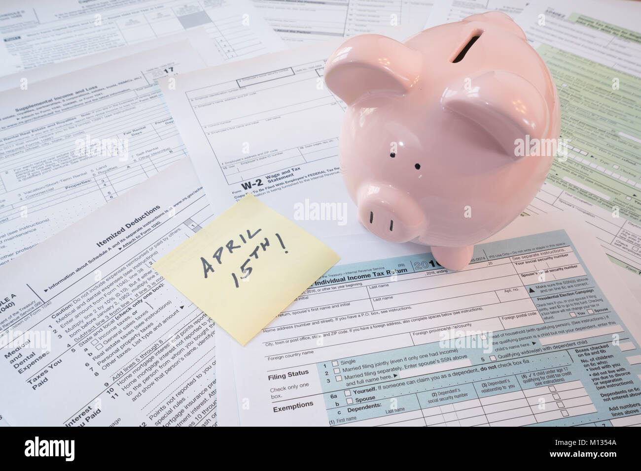 IRS Federal Tax Forms with Piggy Bank with April 15th Reminder Note ...