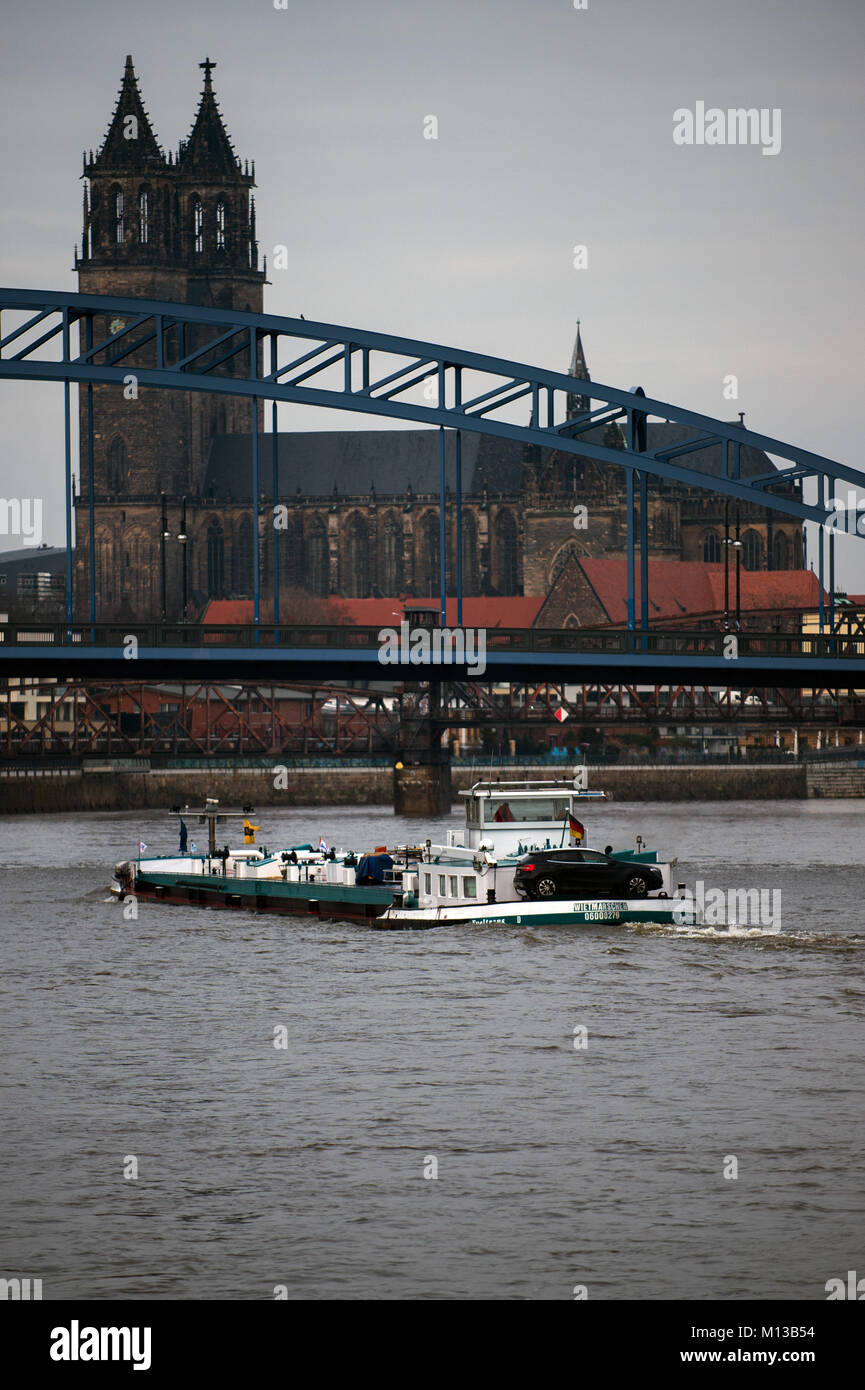 A domestic cargo ship moves past the famous cathedral of Magdeburg ...