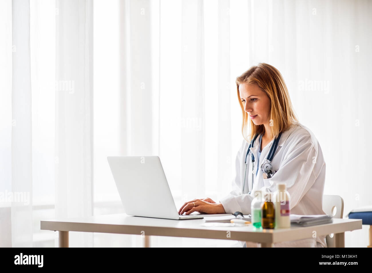 Female doctor with laptop working at the office desk Stock Photo - Alamy