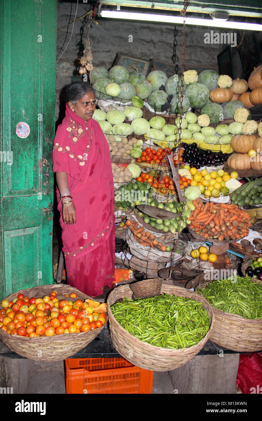 Upright view of woman beside vegetable stall in India Stock Photo - Alamy