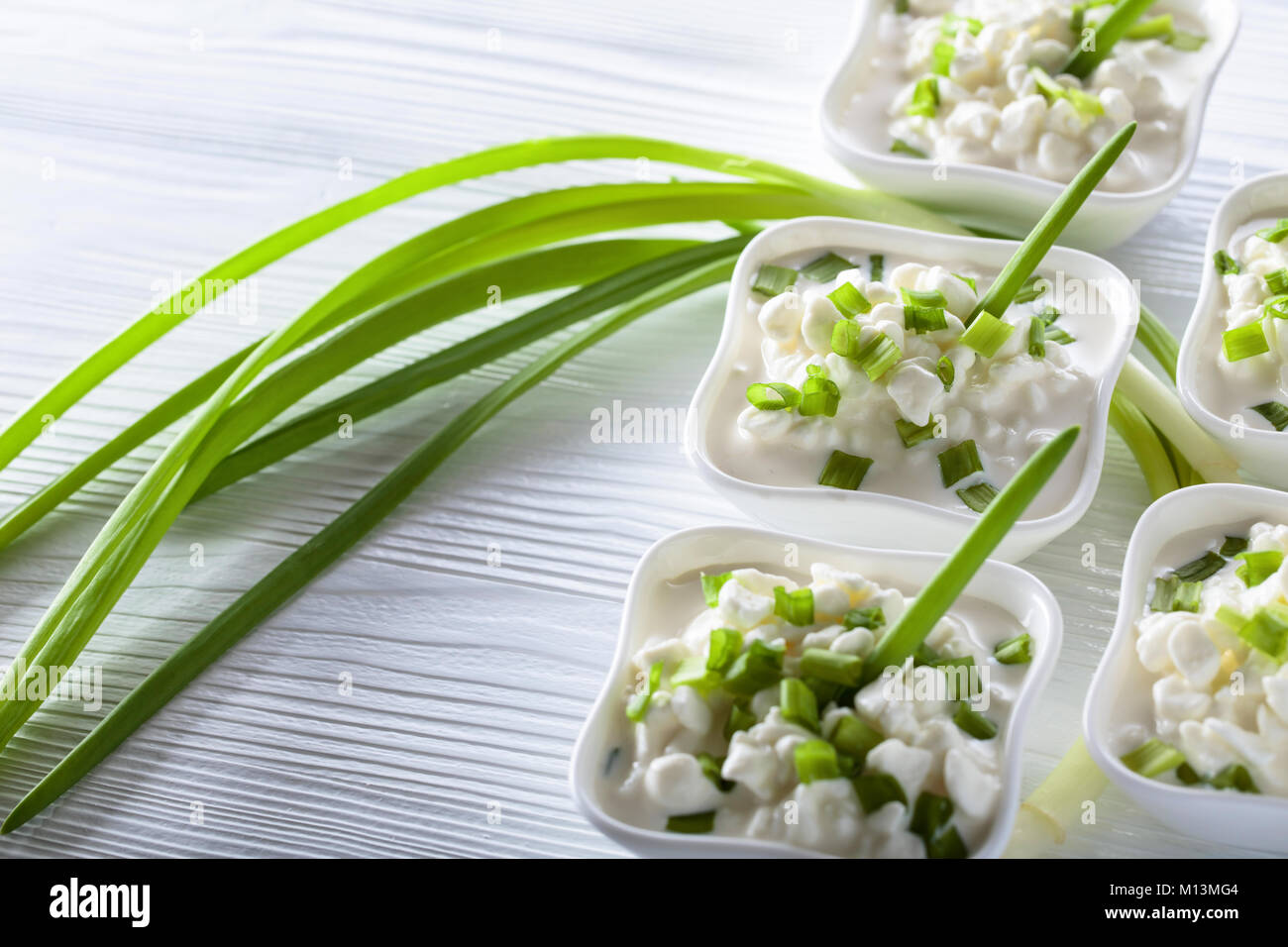 Homemade cottage cheese with green onions on white wooden table Stock ...