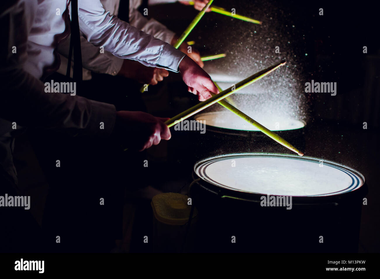 The drum sticks are hitting on the snare drum with splash water in low ...