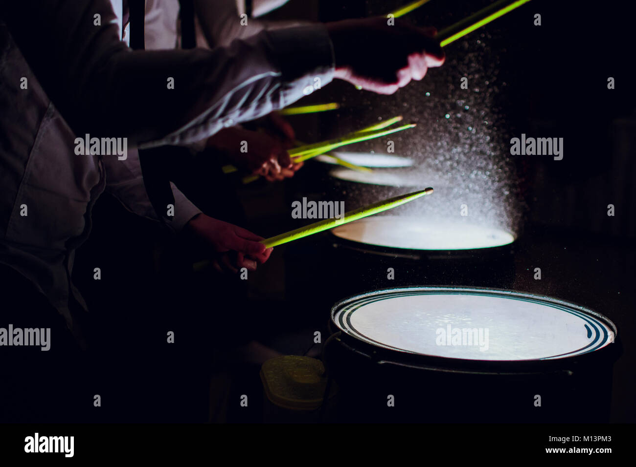 The drum sticks are hitting on the snare drum with splash water in low ...