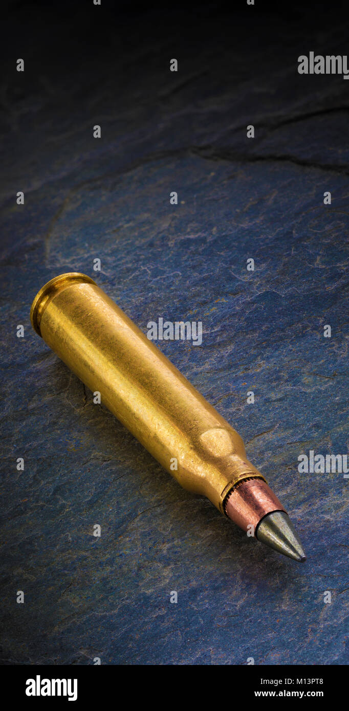 Gray stone with a military M855 EPR at an angle atop Stock Photo - Alamy