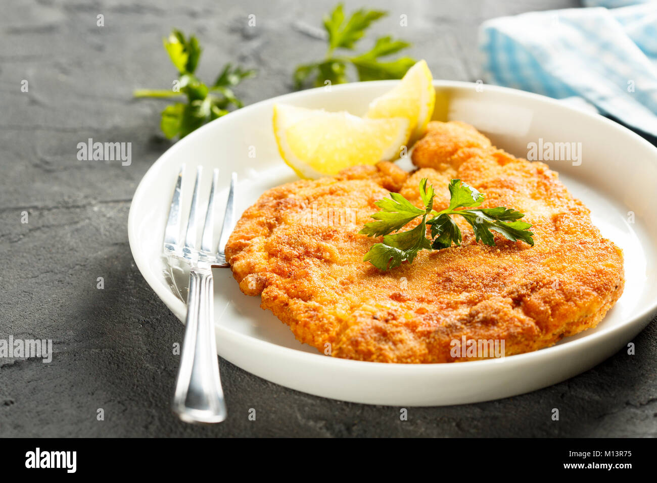 Breaded fried meat with a fresh lemon wedge Stock Photo - Alamy
