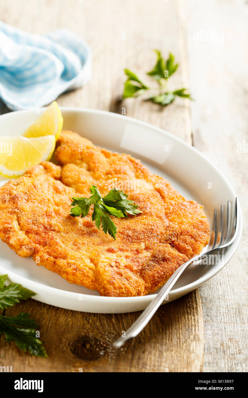 Breaded fried meat with a fresh lemon wedge Stock Photo - Alamy