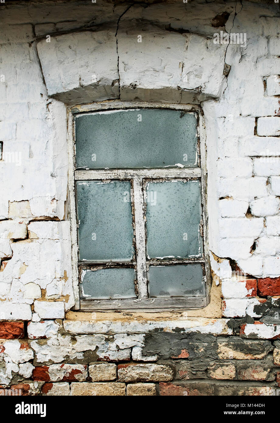 small old window with glass in frost with a rickety wooden frame in the ...