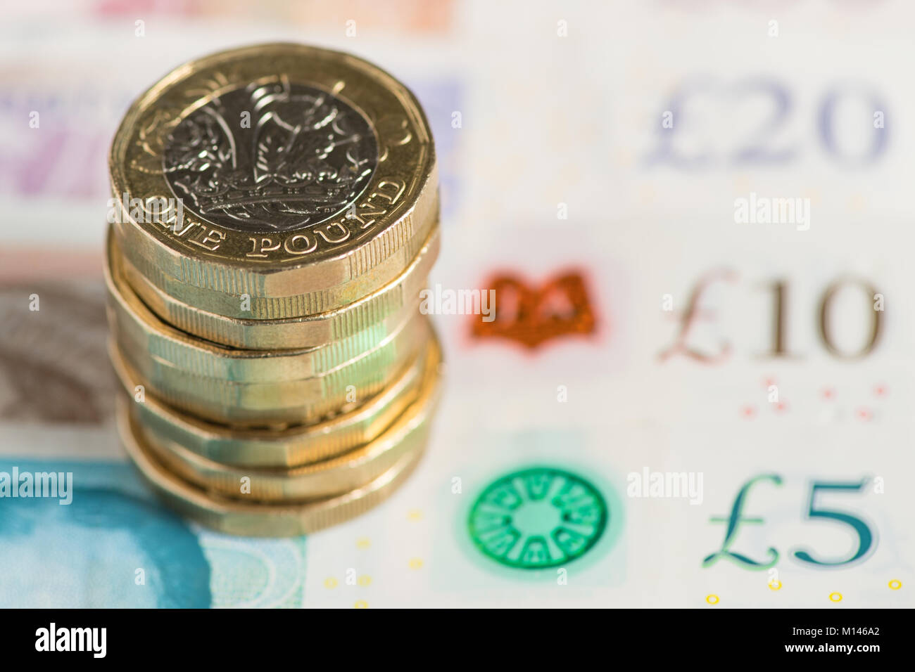 UK five pound, ten pound and twenty pound notes with one pound coins ...