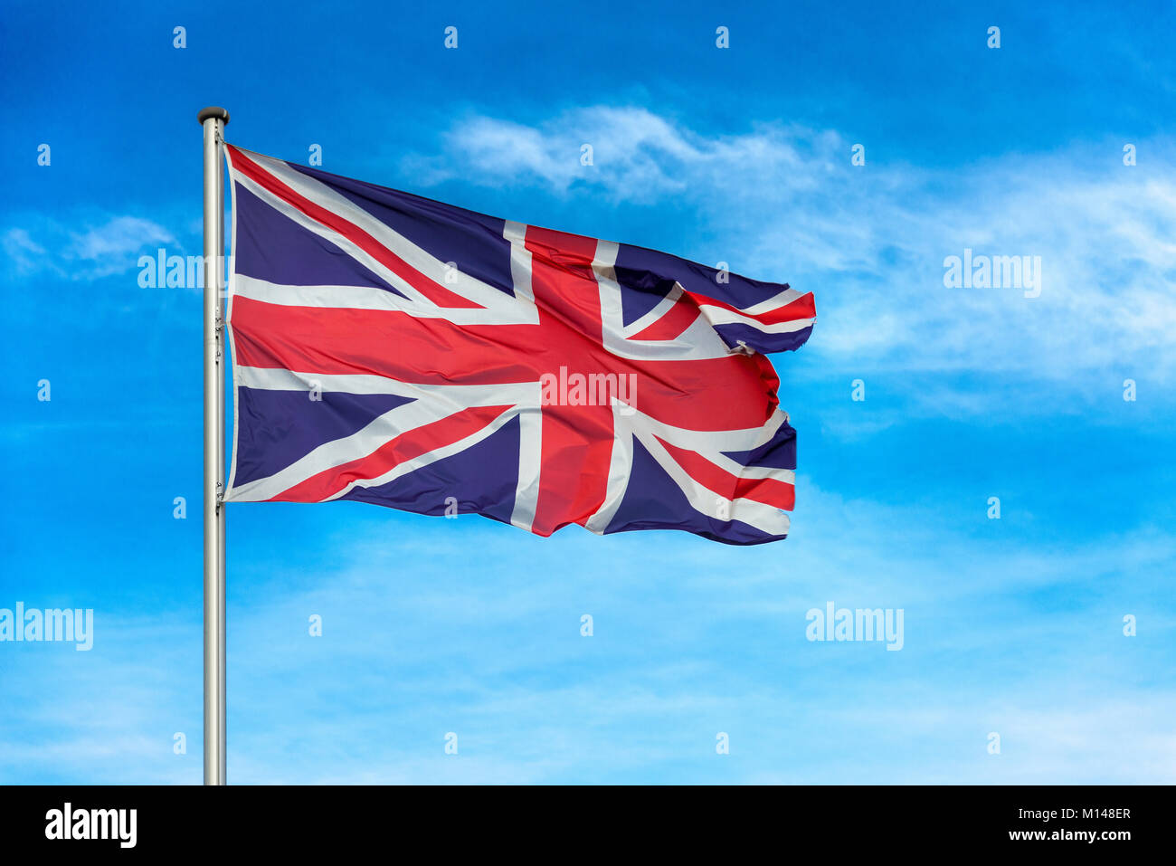 Closeup of single british union jack flag waving in the wind in front ...