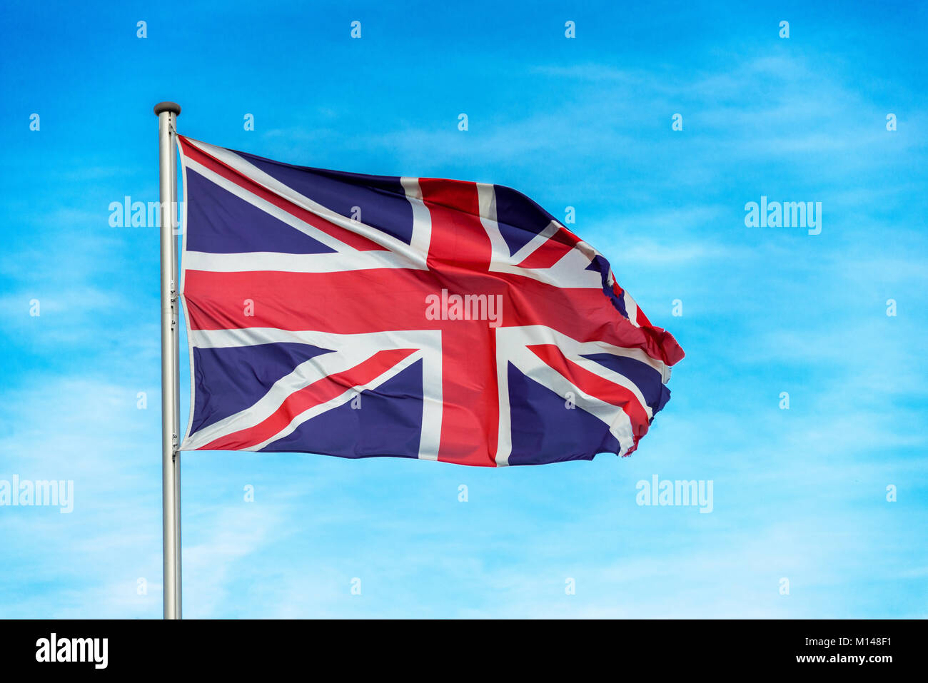 Closeup of single british union jack flag waving in the wind in front ...
