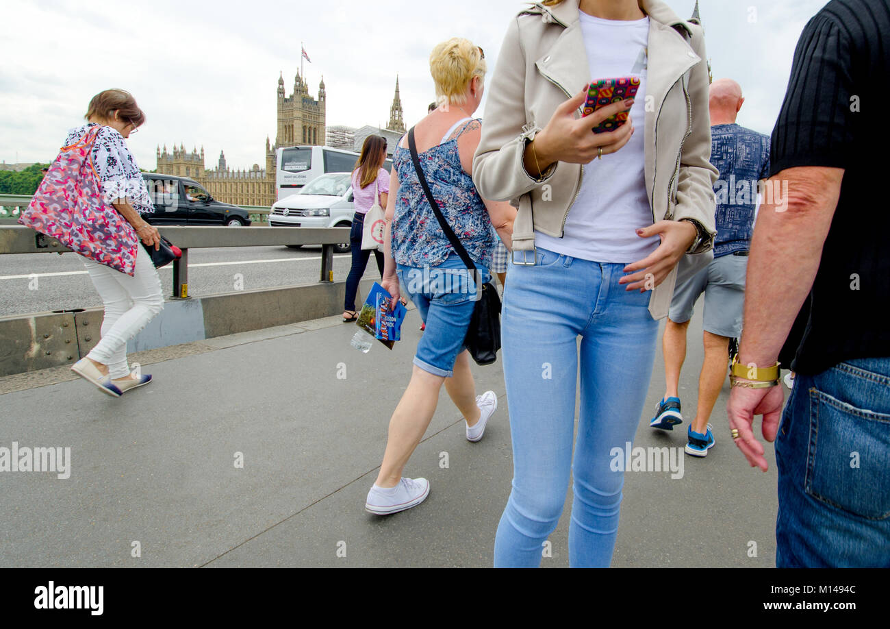 London, England, UK. Young woman with a mobile phone on Westminster ...