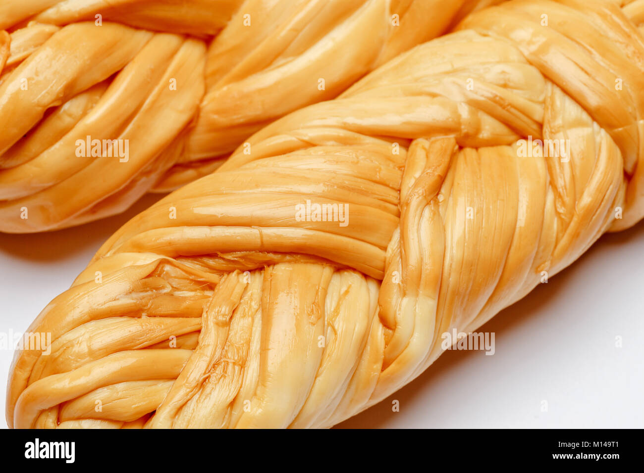Smoked braided cheese isolated on white background Stock Photo - Alamy